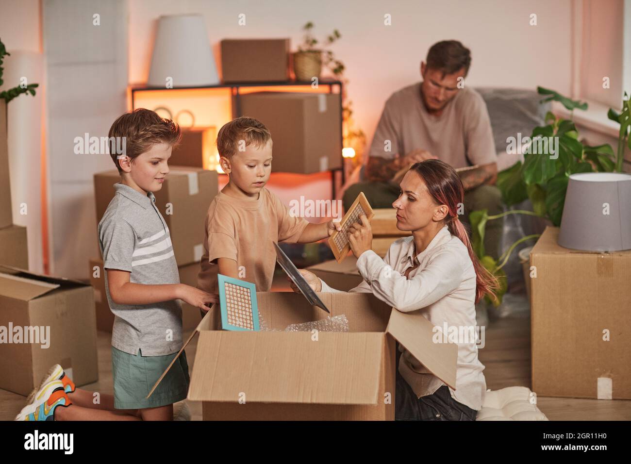 Portrait of big happy family unpacking boxes while moving in to new ...