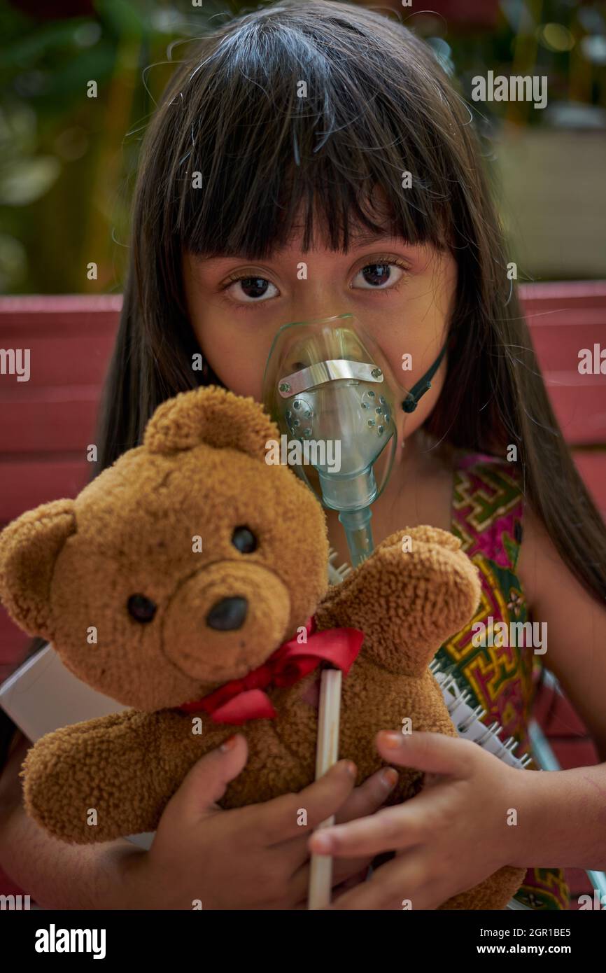 Portrait Of Girl Wearing Oxygen Mask While Sitting With Teddy Bear ...