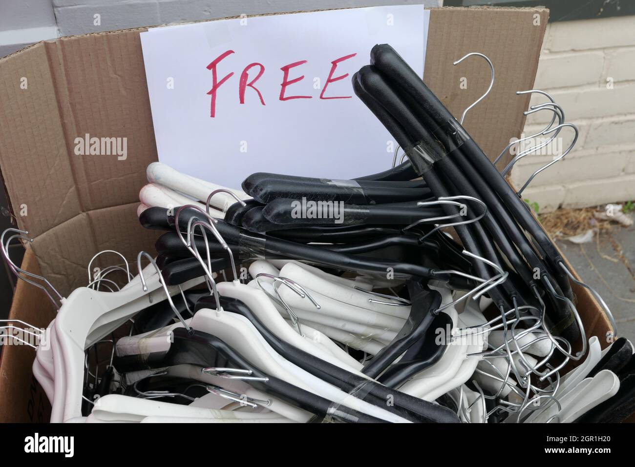Cardboard box of plastic coat hangers being given away free Stock Photo ...