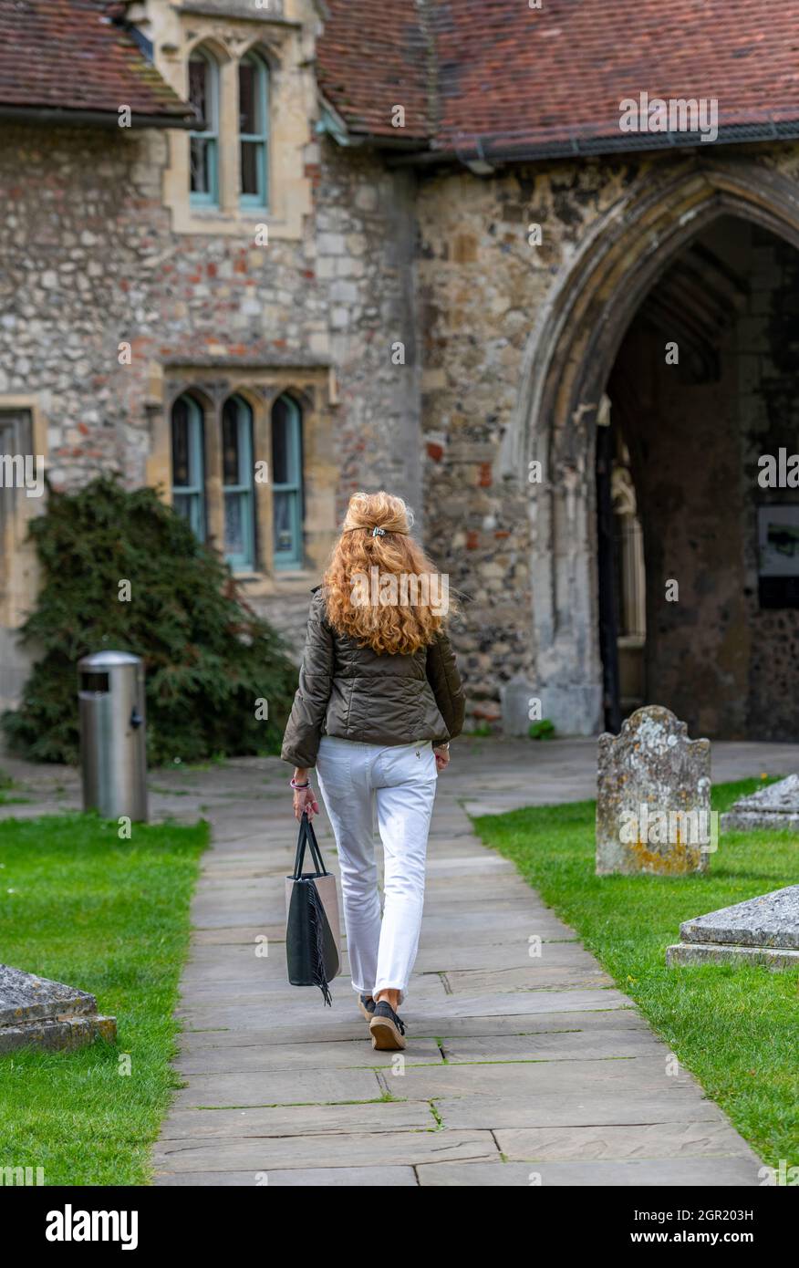 middle-aged woman with long red hair walking home alone through a ...