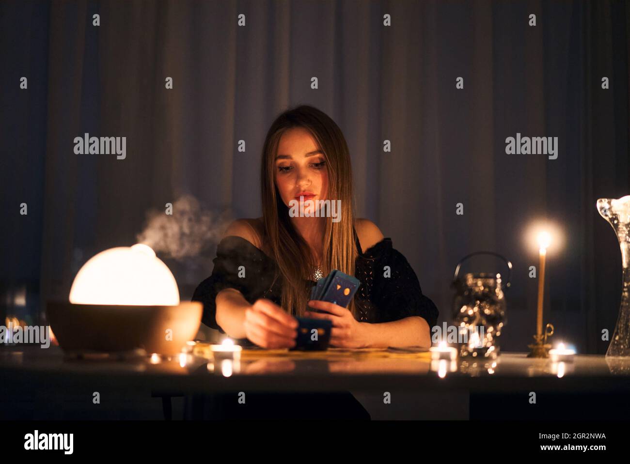 Woman reading tarot cards in spiritual room Stock Photo - Alamy