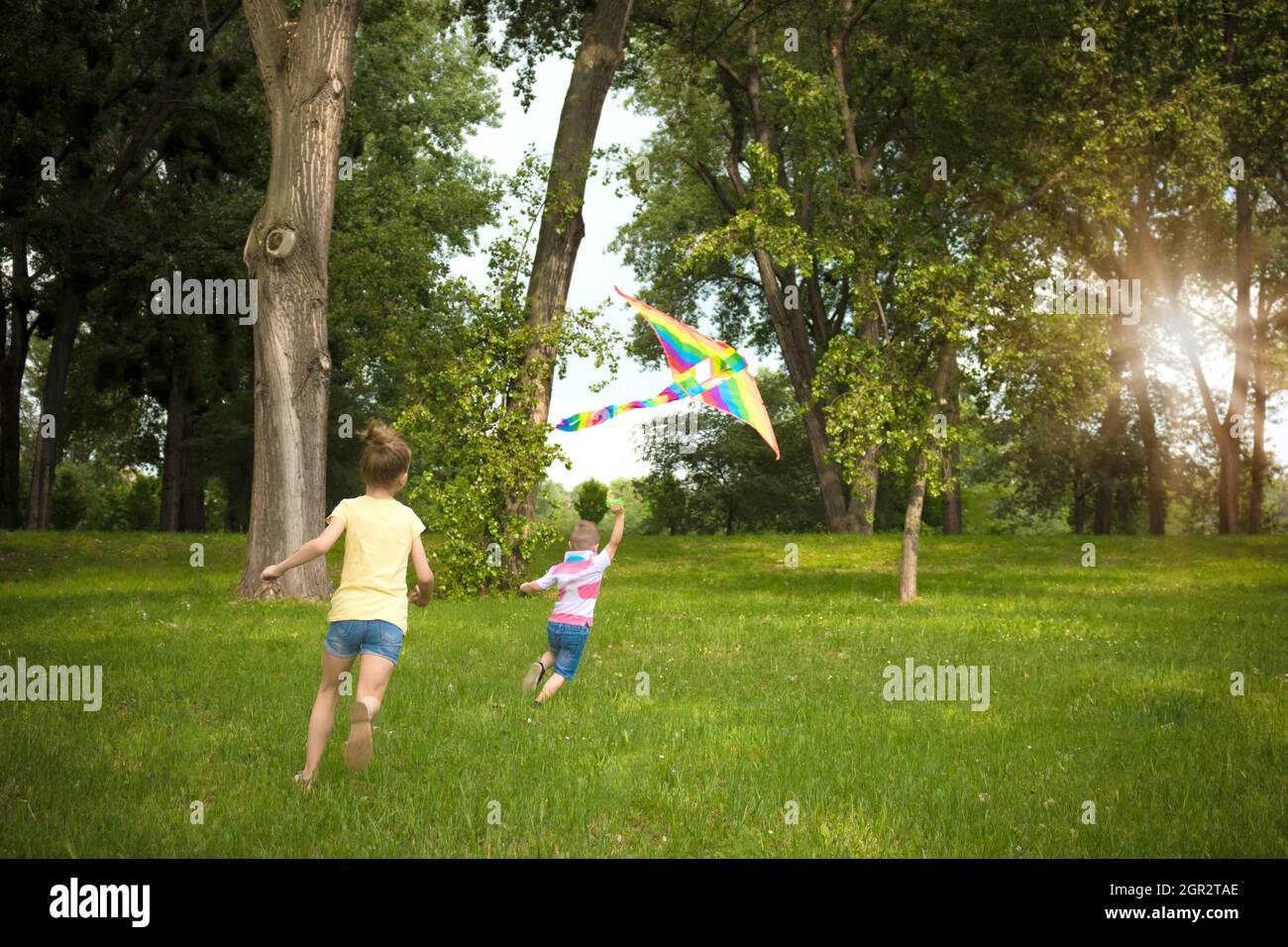 Back View Of Boy And Girl Having Fun While Running With A Kite In The ...