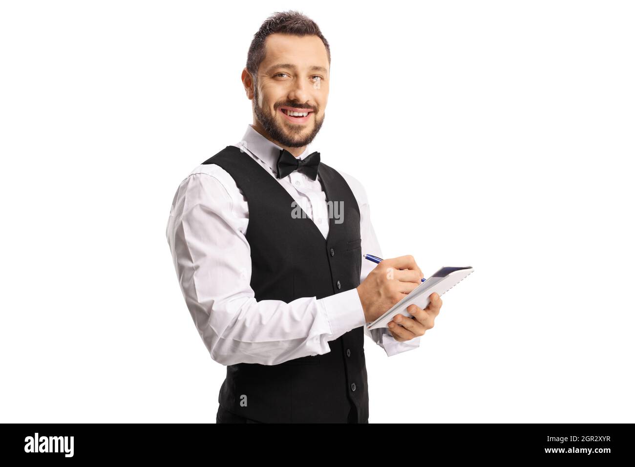 Waiter with a bow tie writing on a paper and smiling isolated on white ...