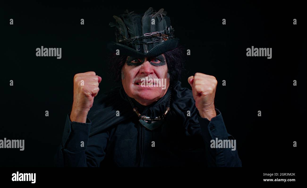 Upset sinister man with horrible scary Halloween witcher makeup raising ...