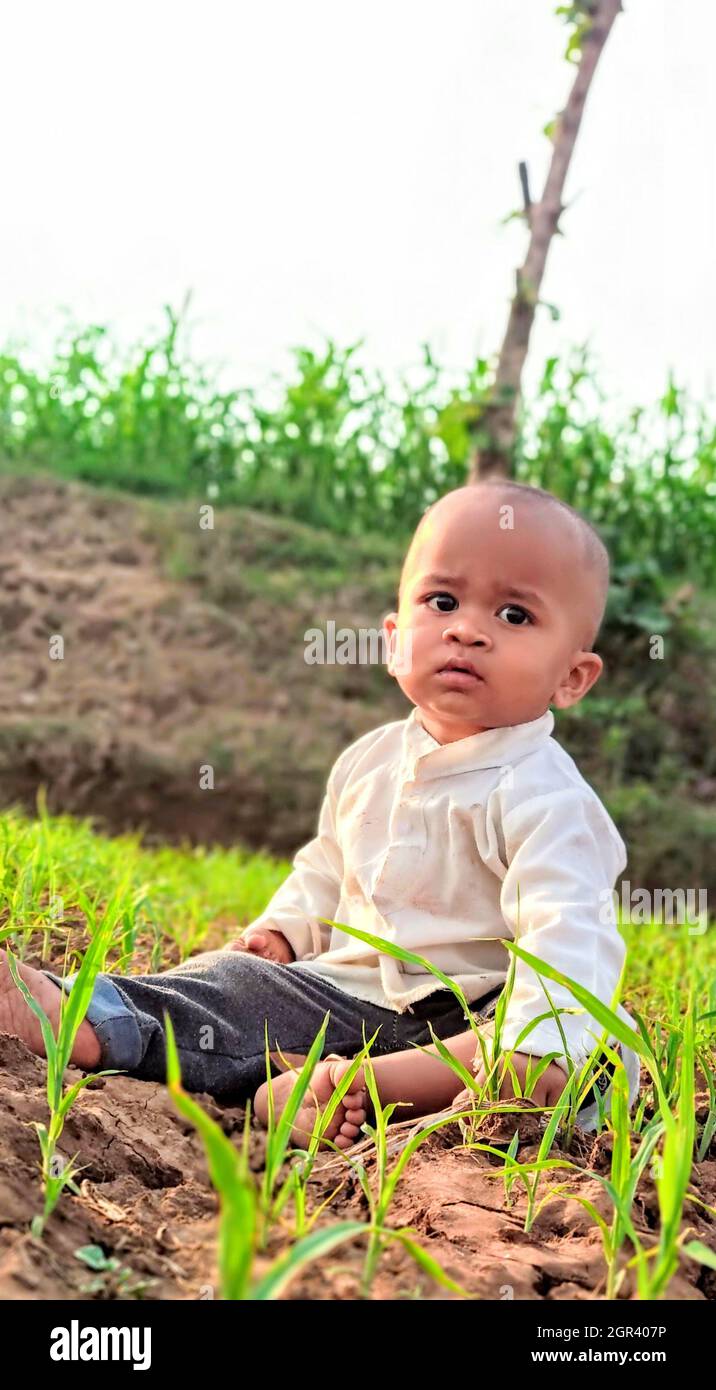 Portrait Of Cute Baby Boy Sitting On Land Stock Photo - Alamy