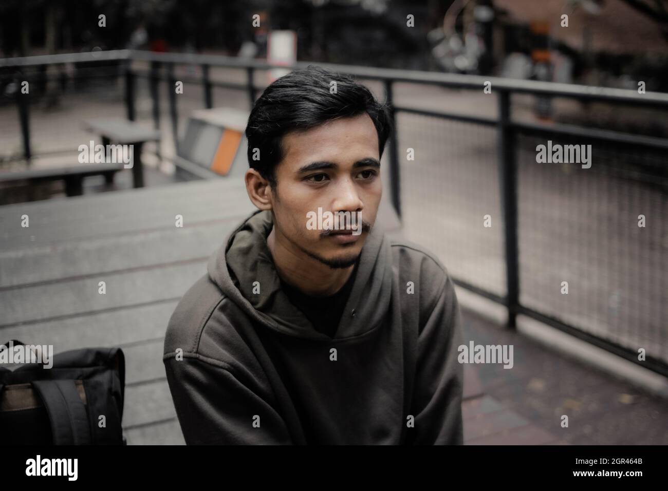 Portrait of young man sitting on railing hi-res stock photography and ...