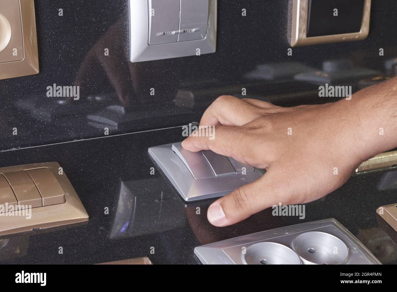 Hand touching a three-key light switch in a store Stock Photo - Alamy
