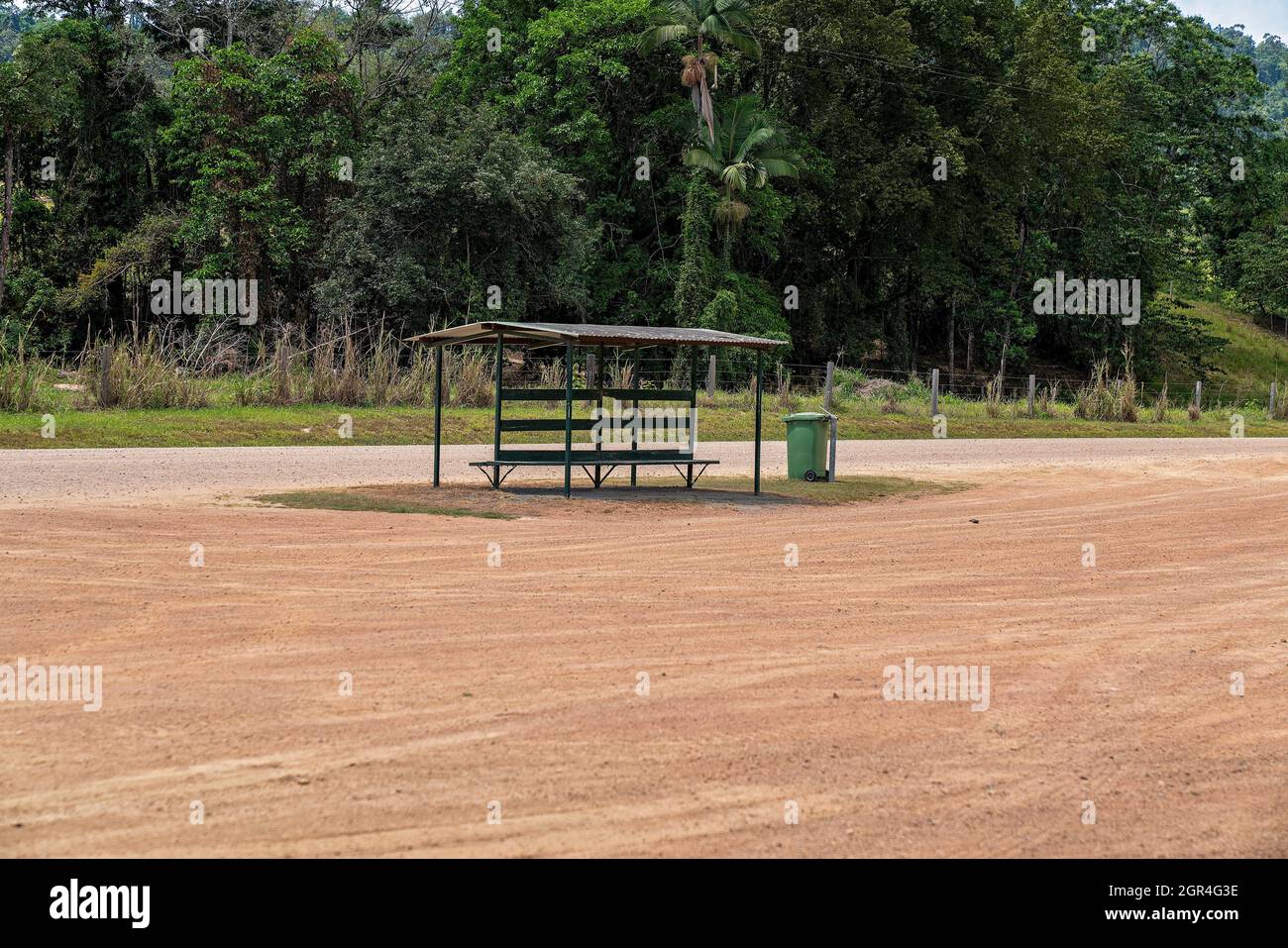 A rural bus stop on a lonely dusty road with forest backdrop Stock ...