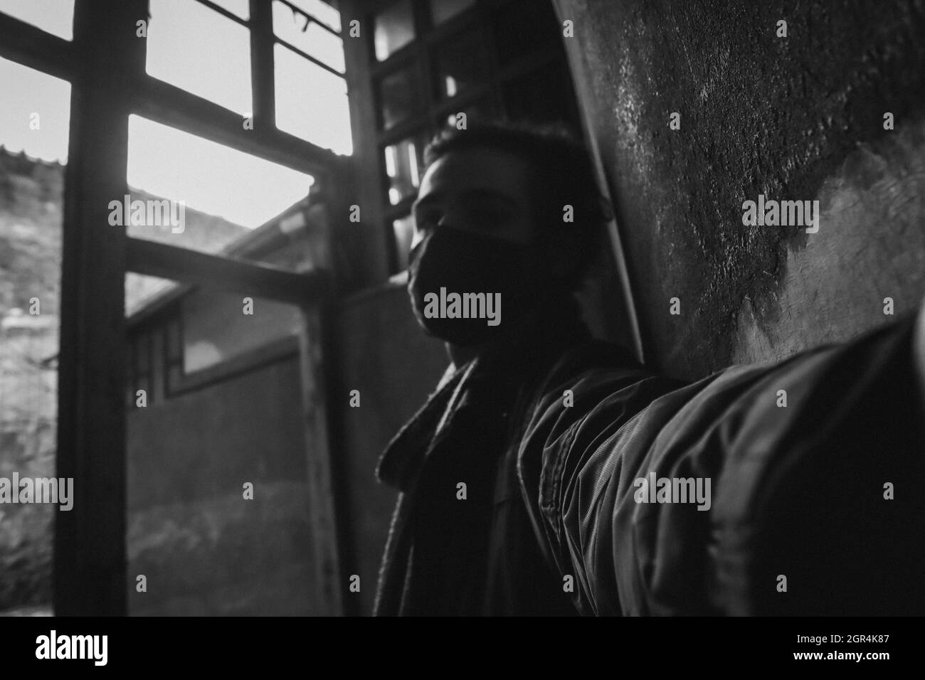 Young man standing window Black and White Stock Photos & Images - Alamy