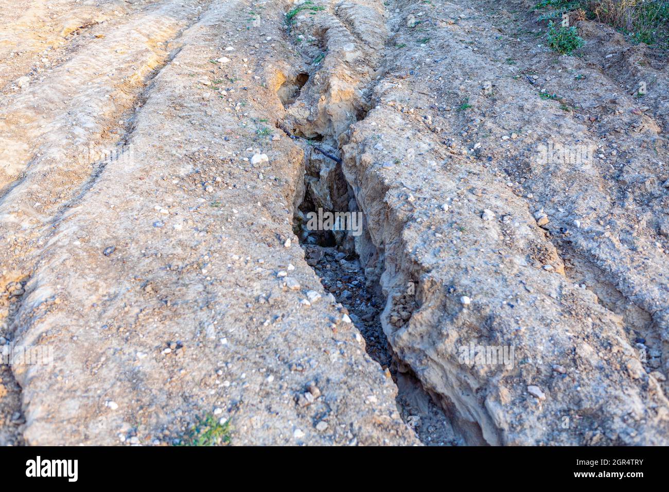 Country road washed away by the downpour . Holes in the ground after ...