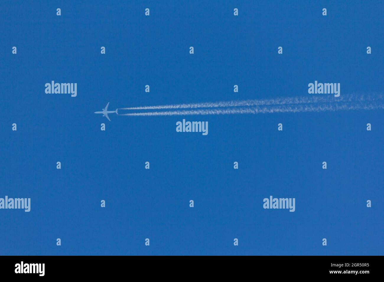 Flying plane leaves an inversion trail in the air Stock Photo - Alamy