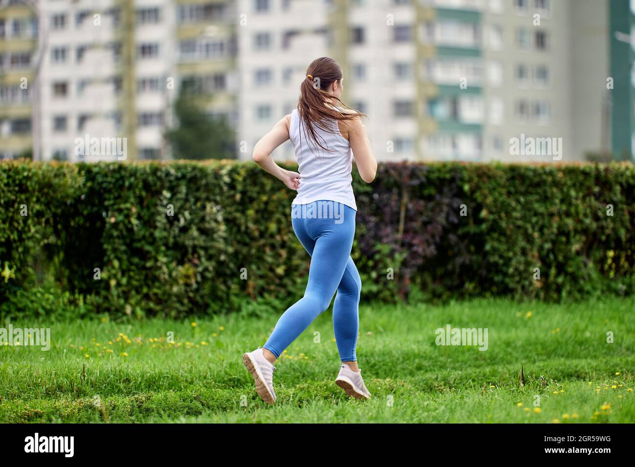 Back view of running young graceful woman outdoors Stock Photo - Alamy