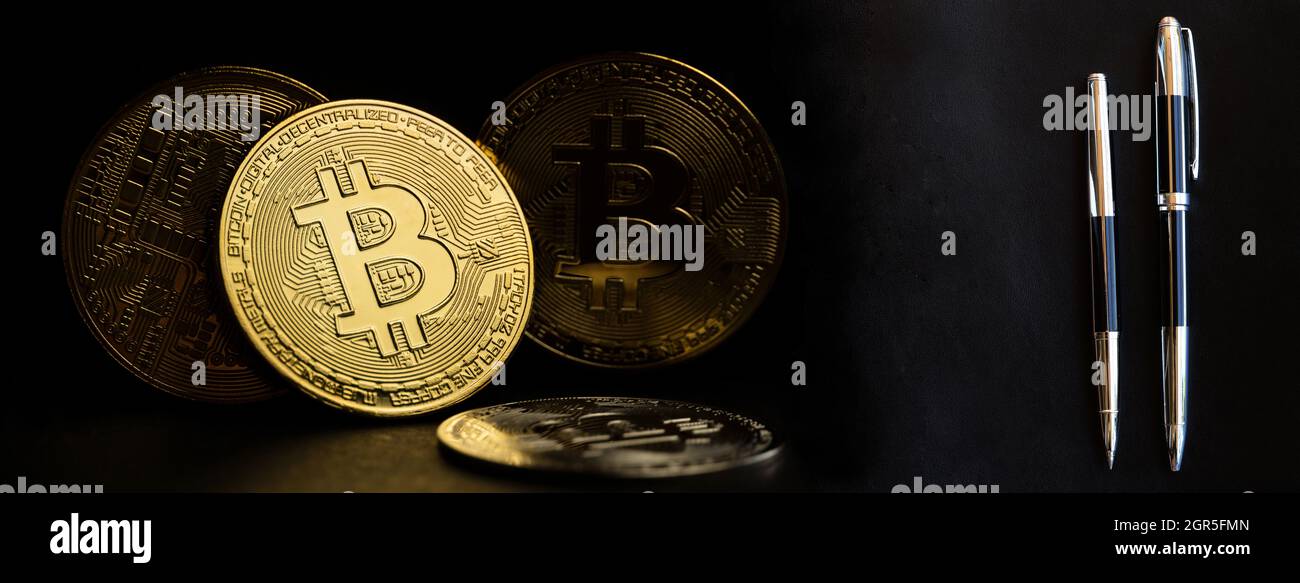 glowing golden model of bitcoin crypto currency with luxury pen ...