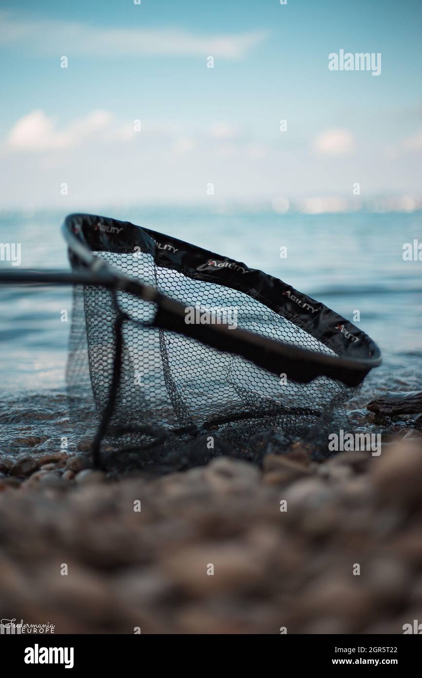 Selective of a fishing net on a ple on the water Stock Photo - Alamy