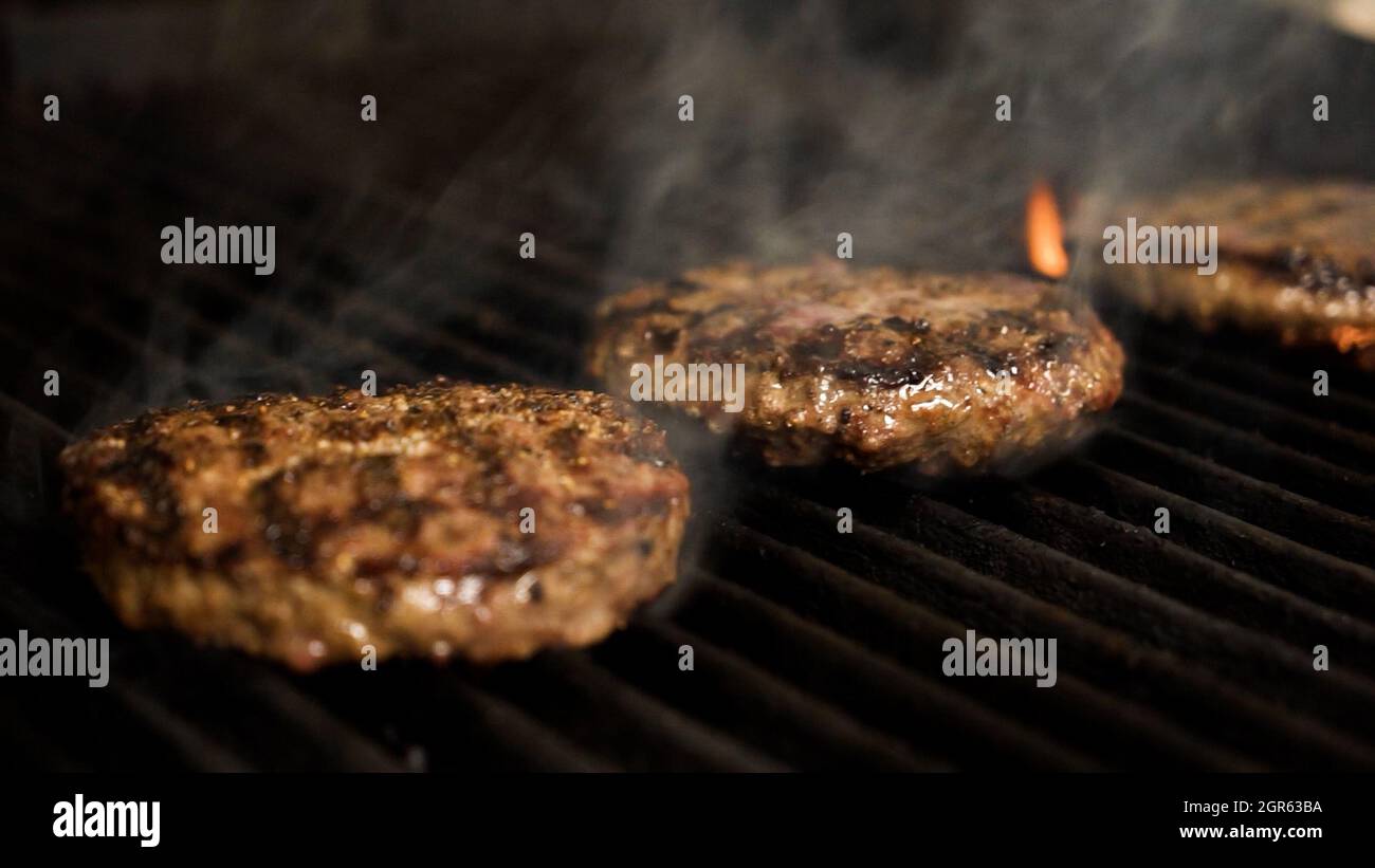 Closeup of burgers cooking on a grill Stock Photo - Alamy