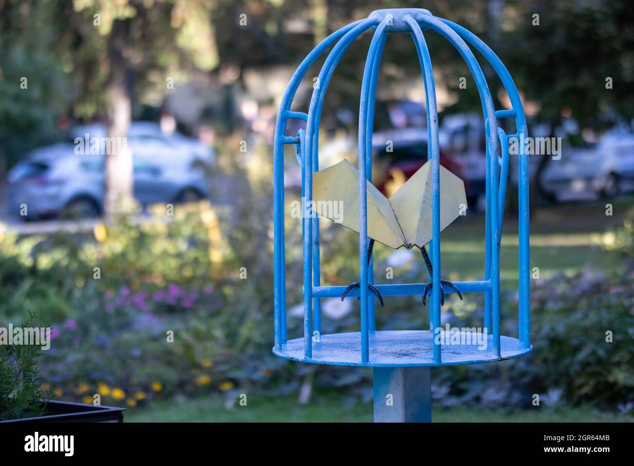 Close up shot of a blue cage for a little bird in a public beautiful ...