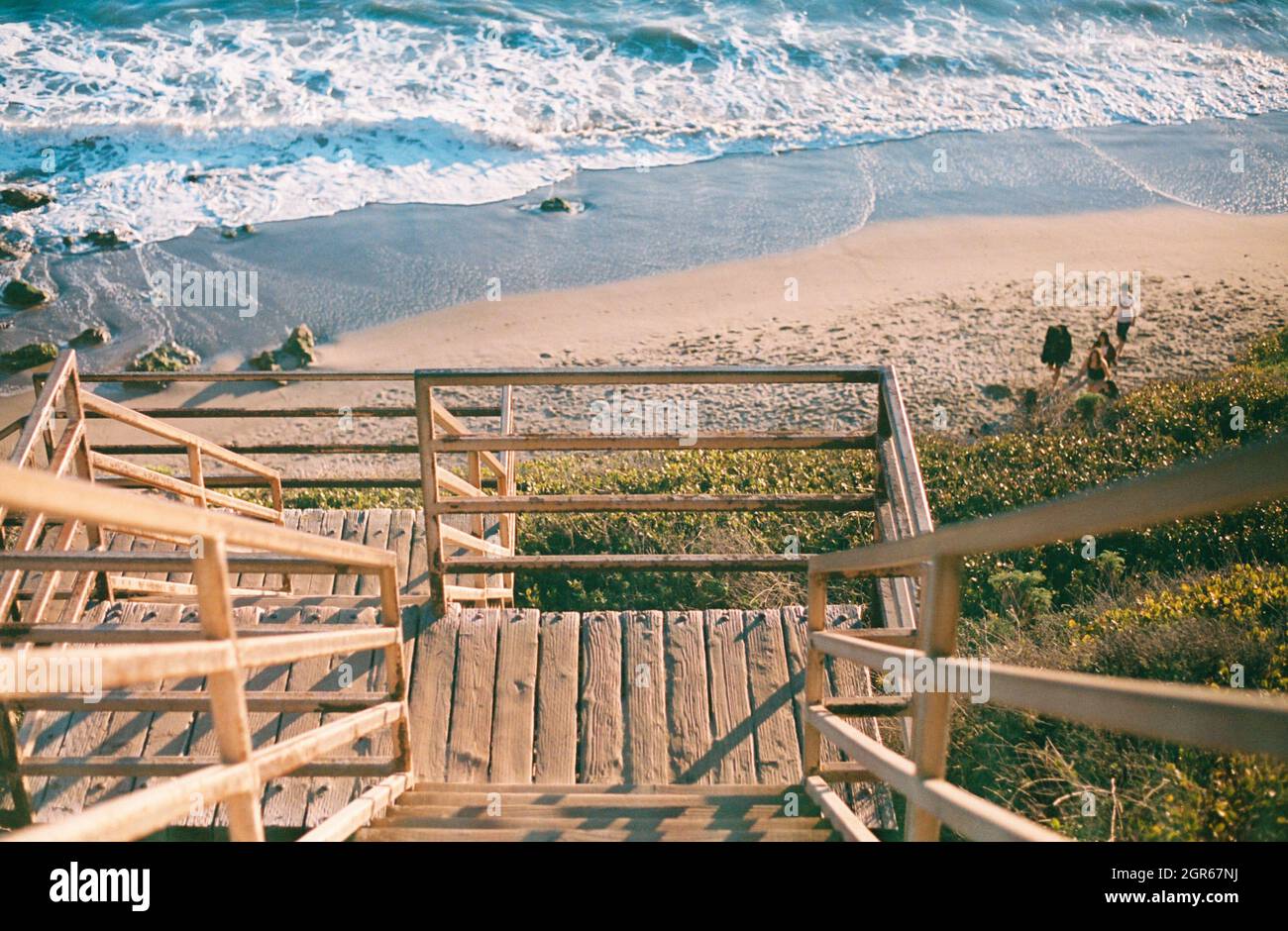 Wooden staircase of a deck on the beach surrounded by the sea on a ...