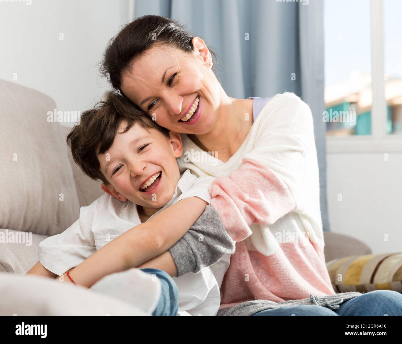 Happy woman hugging son Stock Photo - Alamy