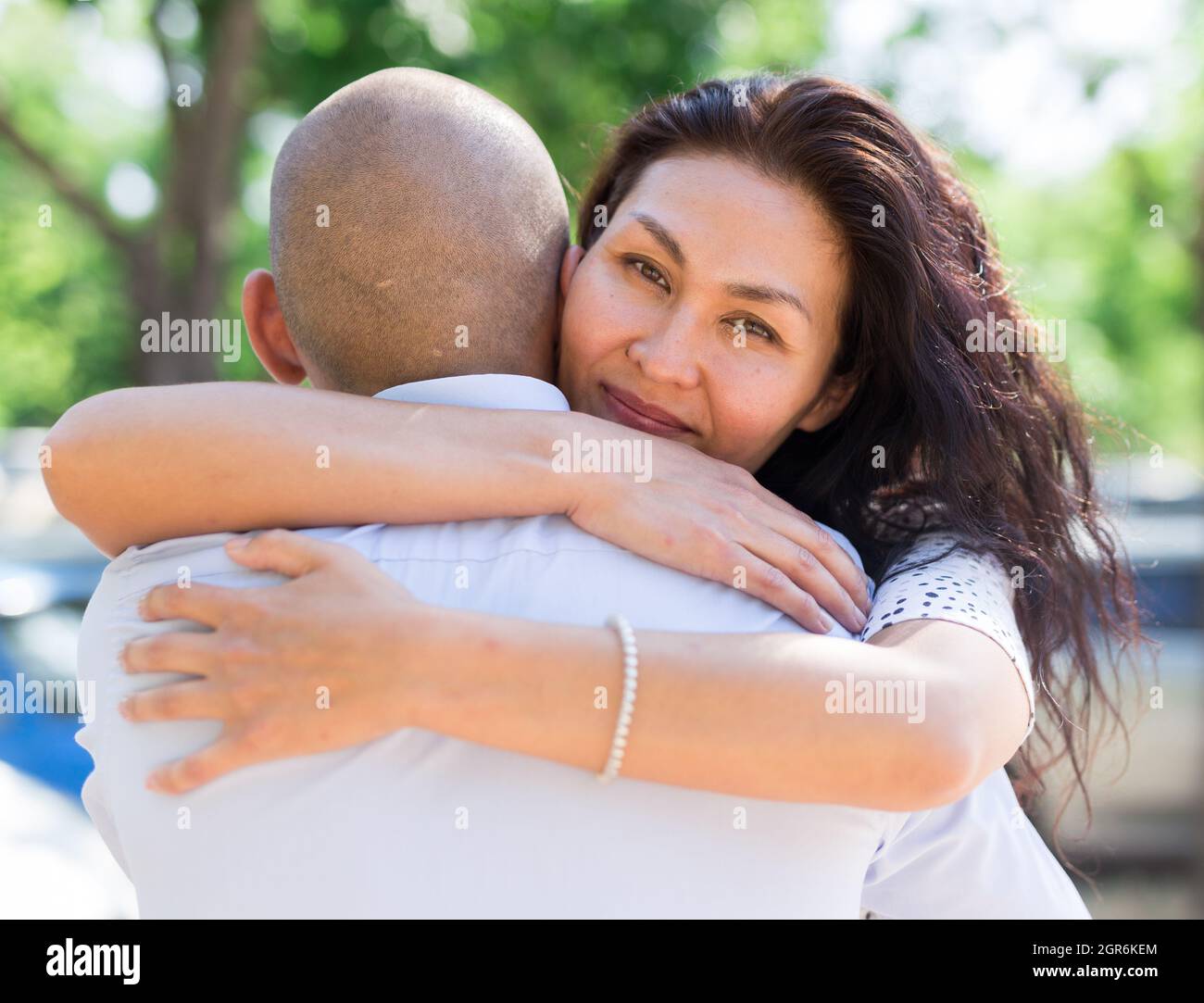 Woman and man hugging in parking lot Stock Photo - Alamy