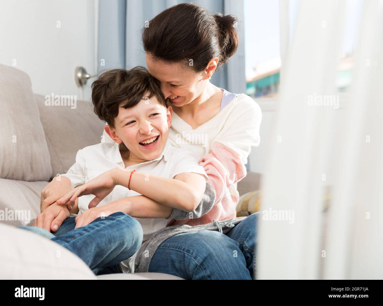 Happy woman hugging son Stock Photo - Alamy