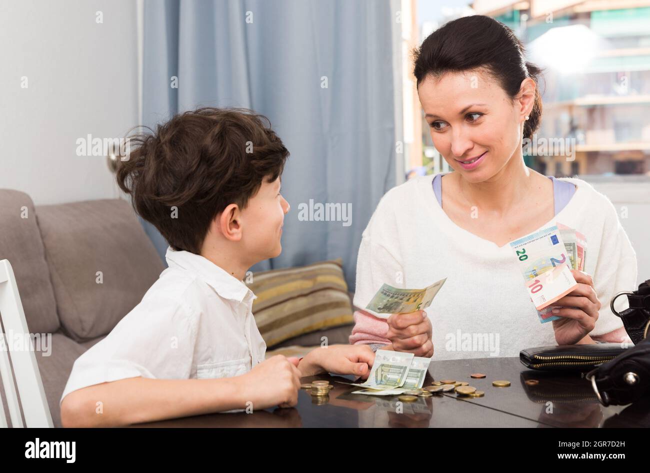 Woman giving money to boy Stock Photo - Alamy