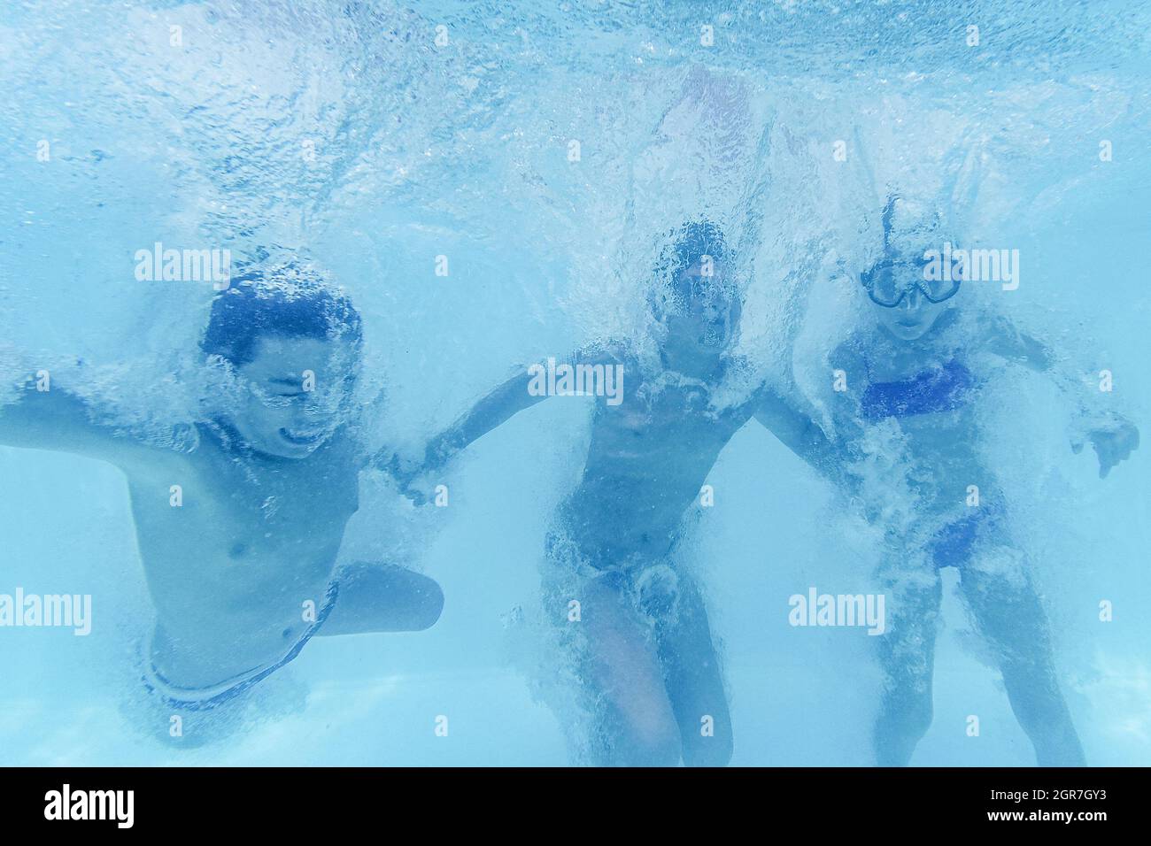 Happy Children Jumping Into A Swimming Pool Stock Photo - Alamy