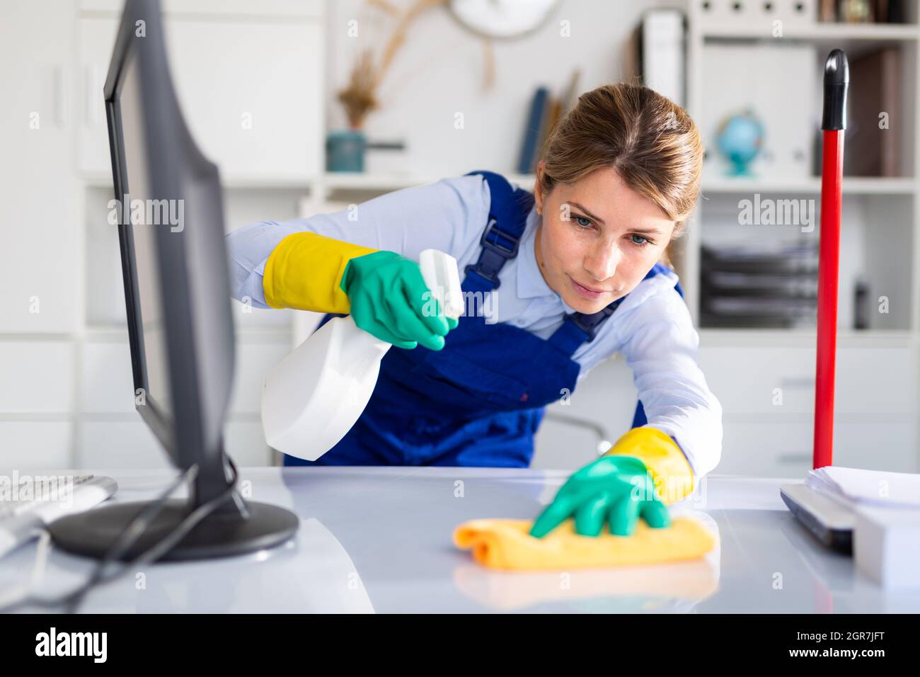 adult female cleaner with cleaning supplies washing in cabinet Stock ...
