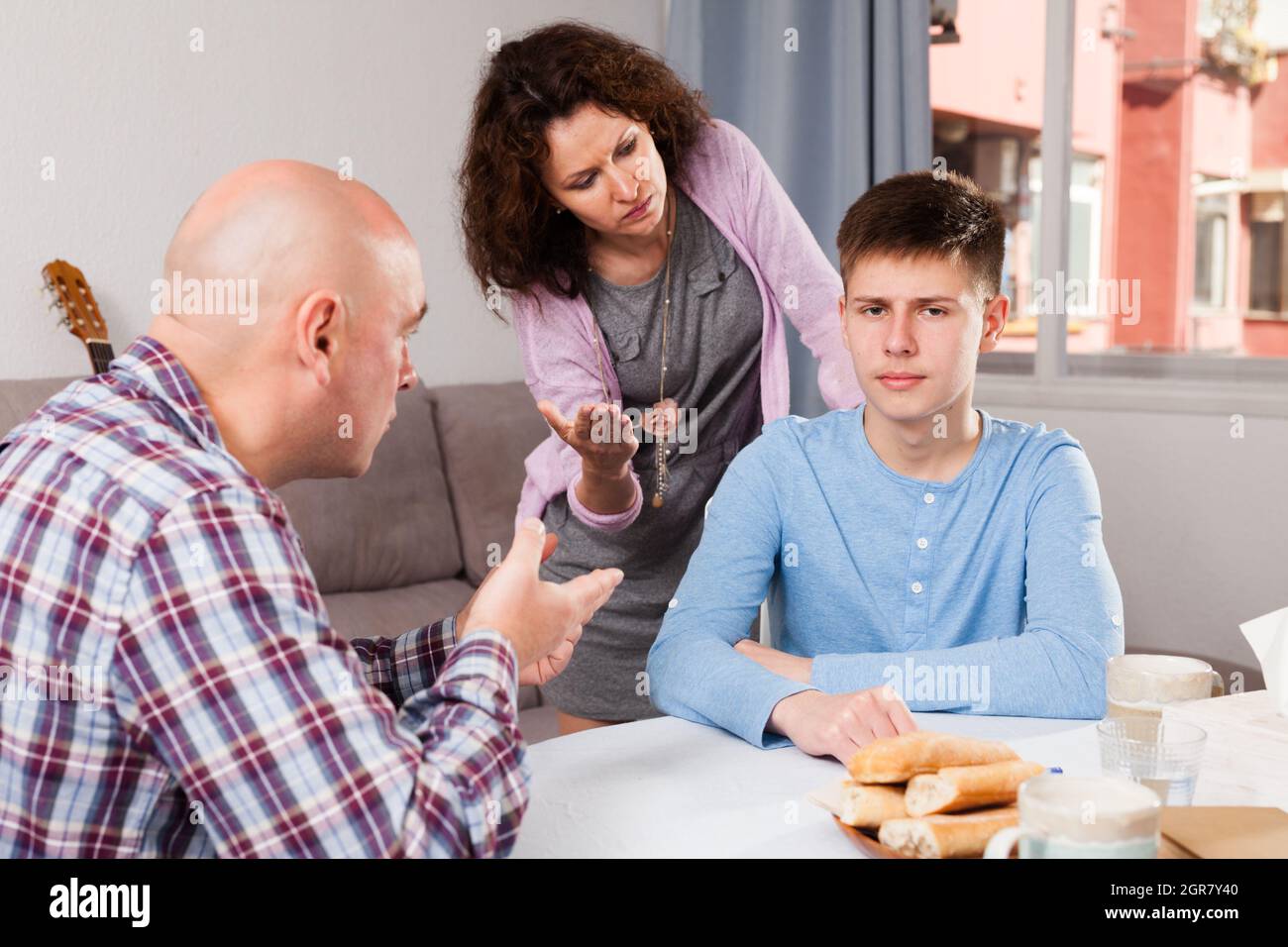 Teenager listening to reprimanding parents Stock Photo - Alamy