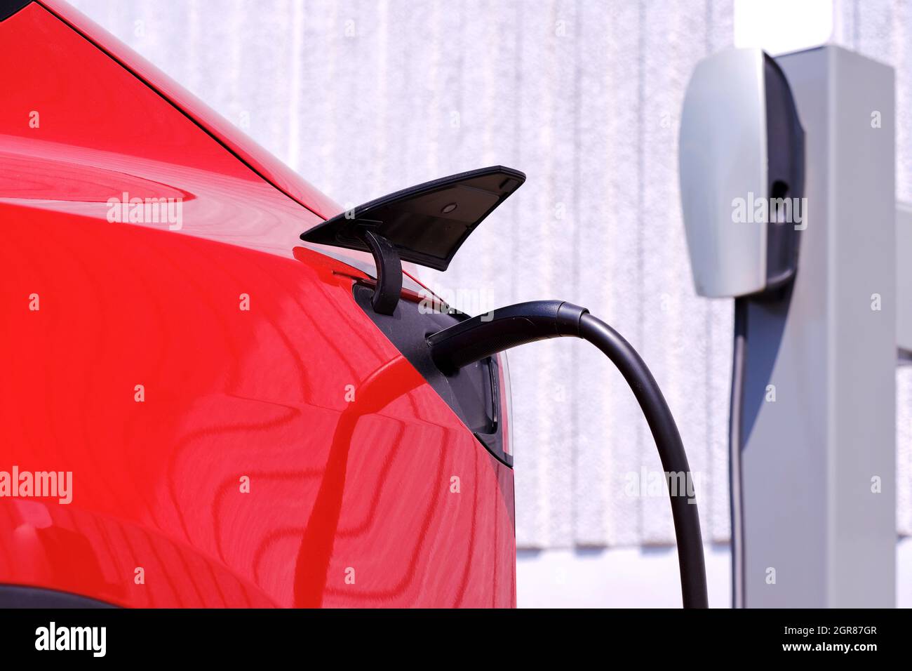 Side view of Electric car charging with plugin power cable connected to ...