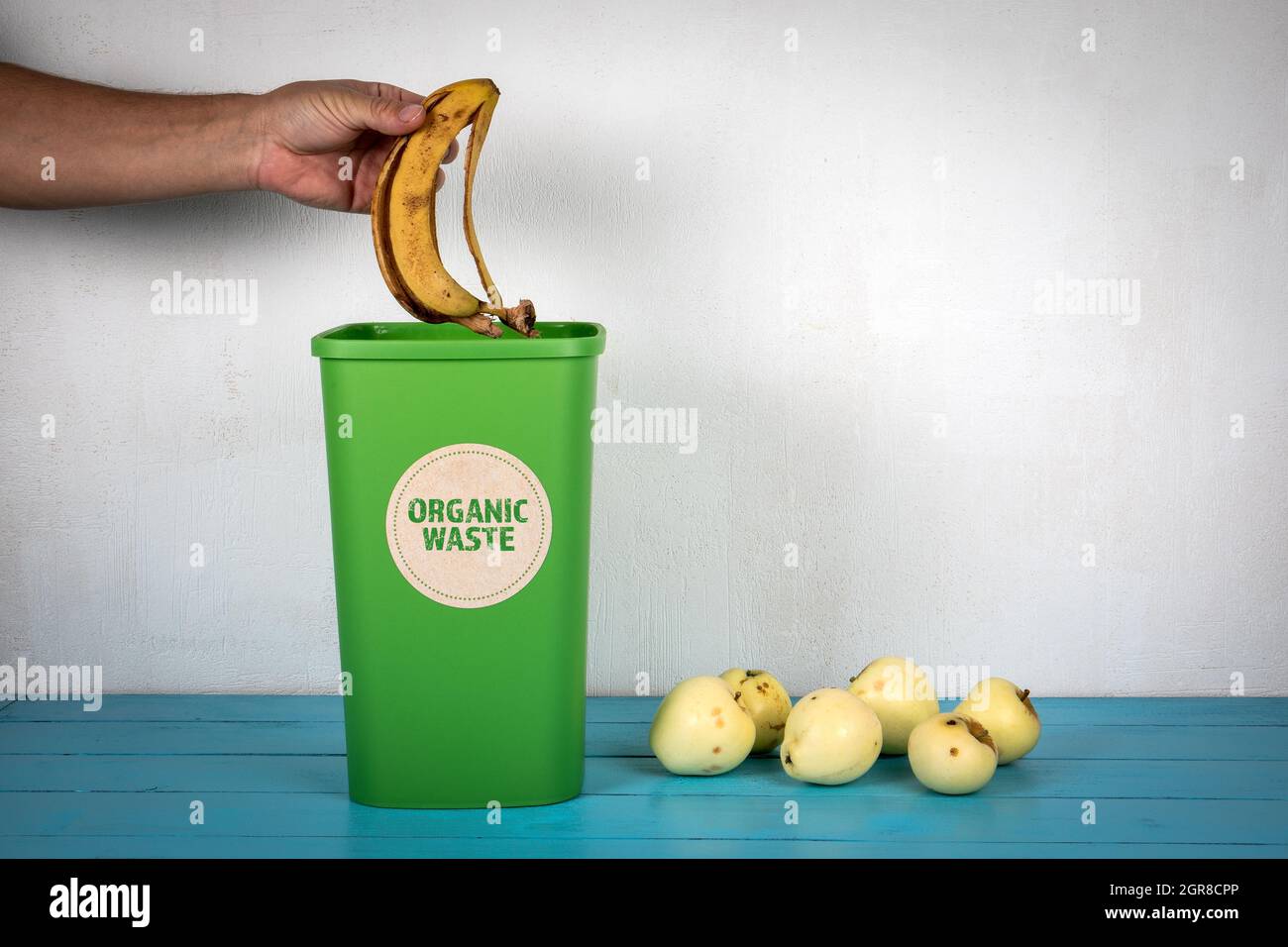 Organic Waste. Man 's hand throws a banana peel in a green waste ...