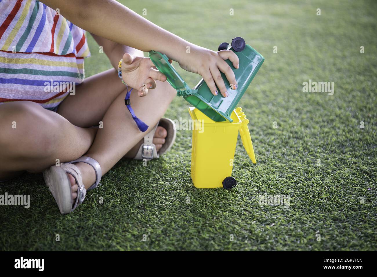 Unrecognizable Caucasian girl playing with green and yellow toy ...