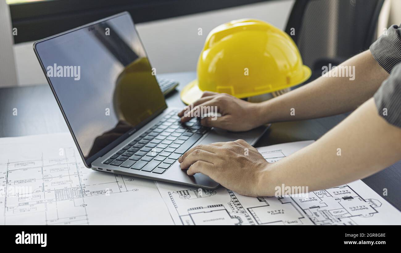 Young Man With A Laptop Plotting A System Of Building Structures In ...