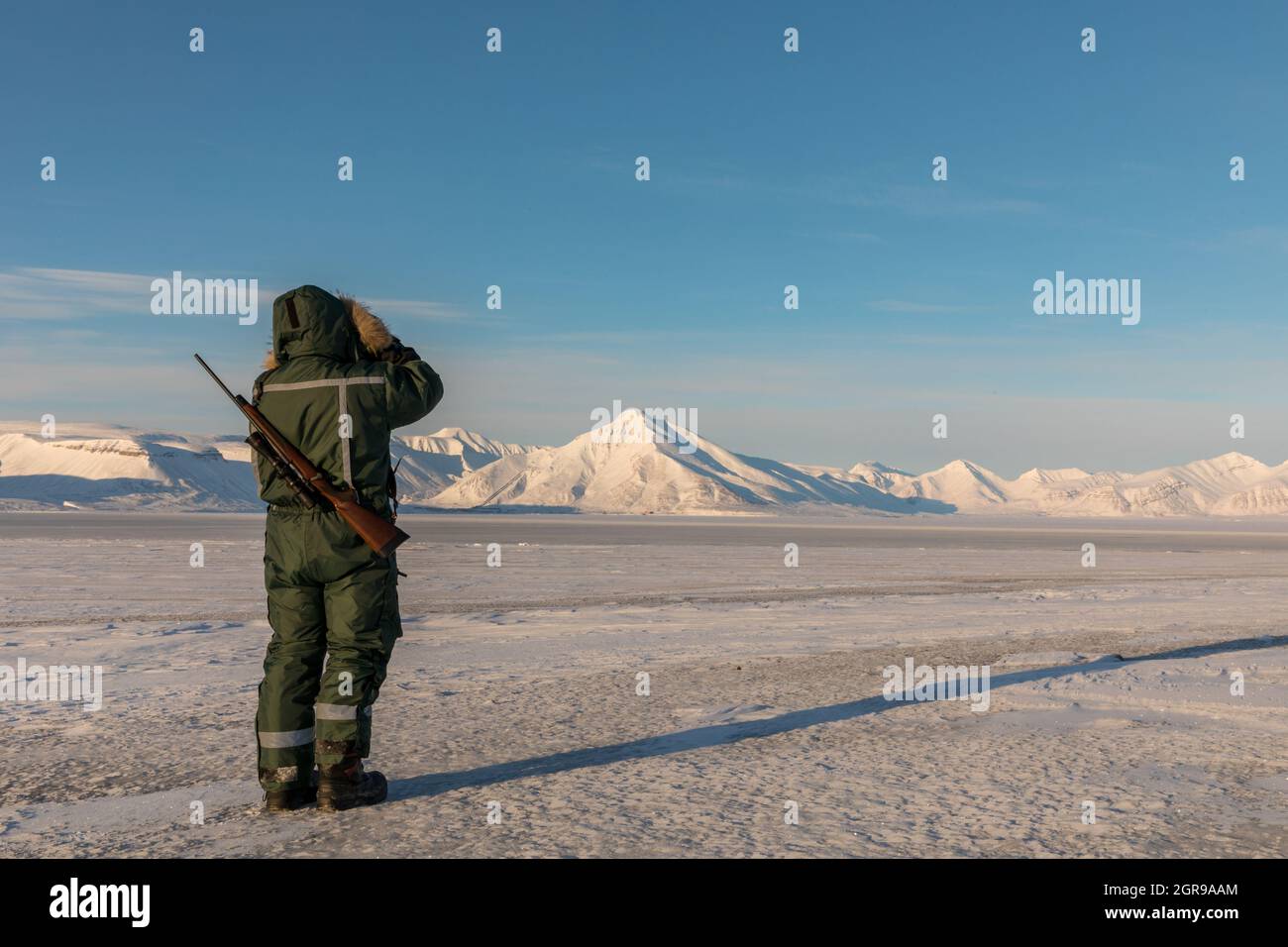Man with a rifle and binoculars in arctic landscape at Svalbard Stock ...