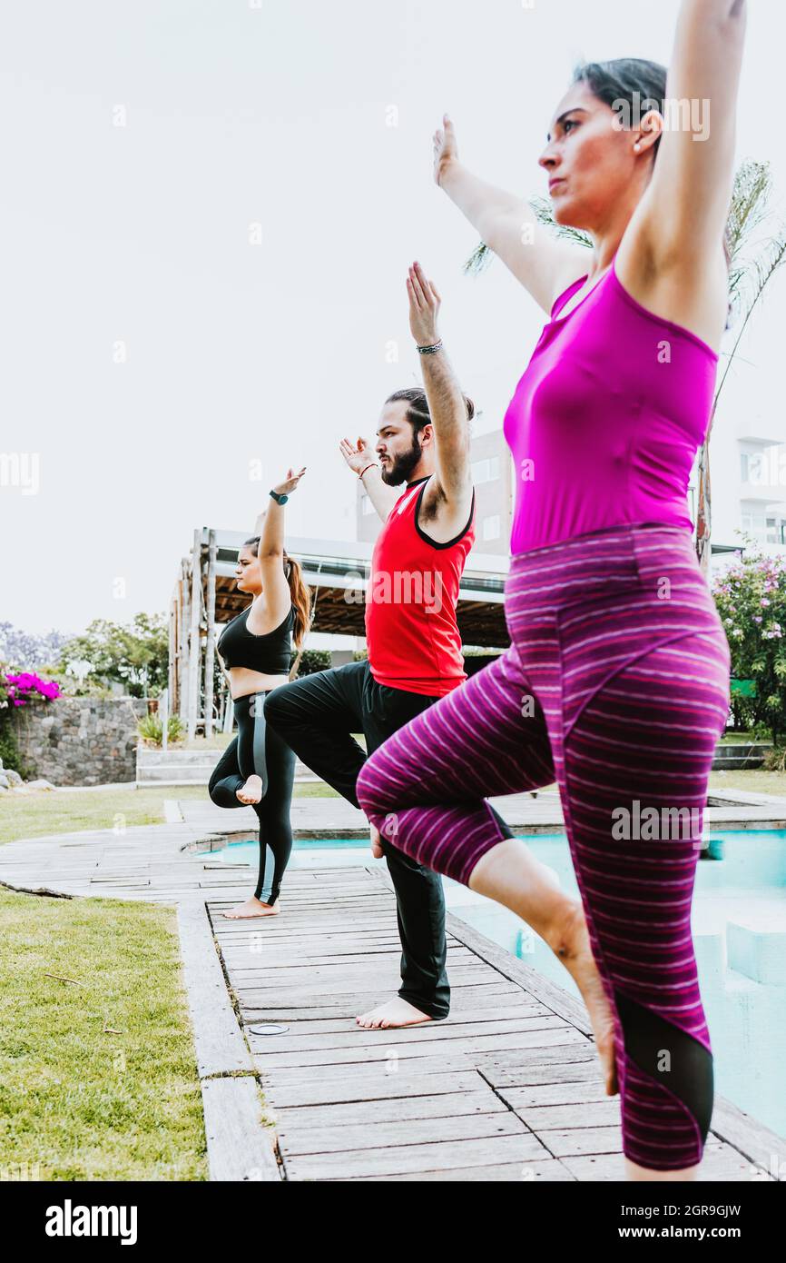Group of latin people practicing yoga poses standing outdoors in Latin ...