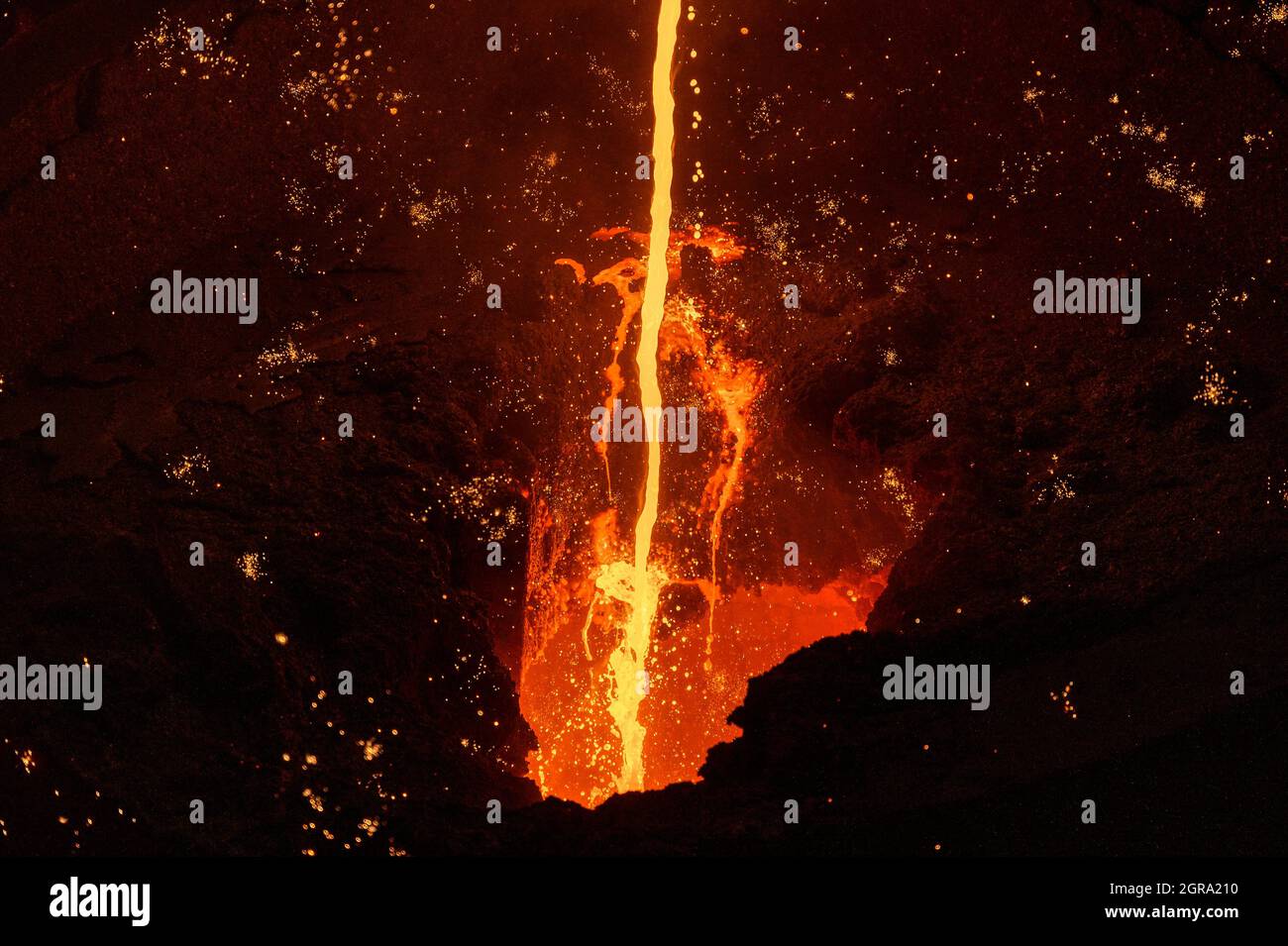 Liquid cast iron is poured into the ladle in a thin stream. Lots of ...