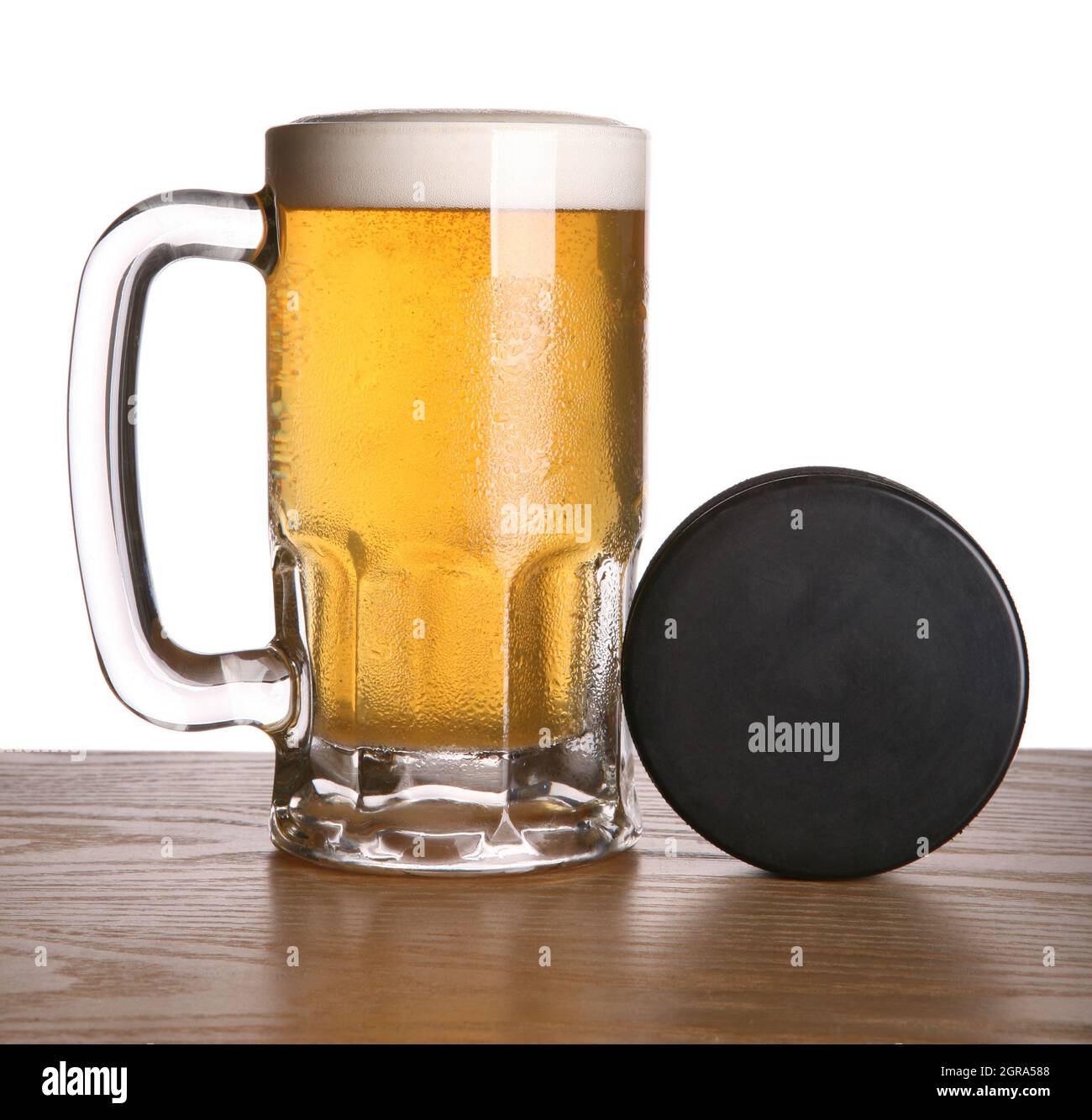 Beer and Hockey Puck on wooden counter Stock Photo - Alamy