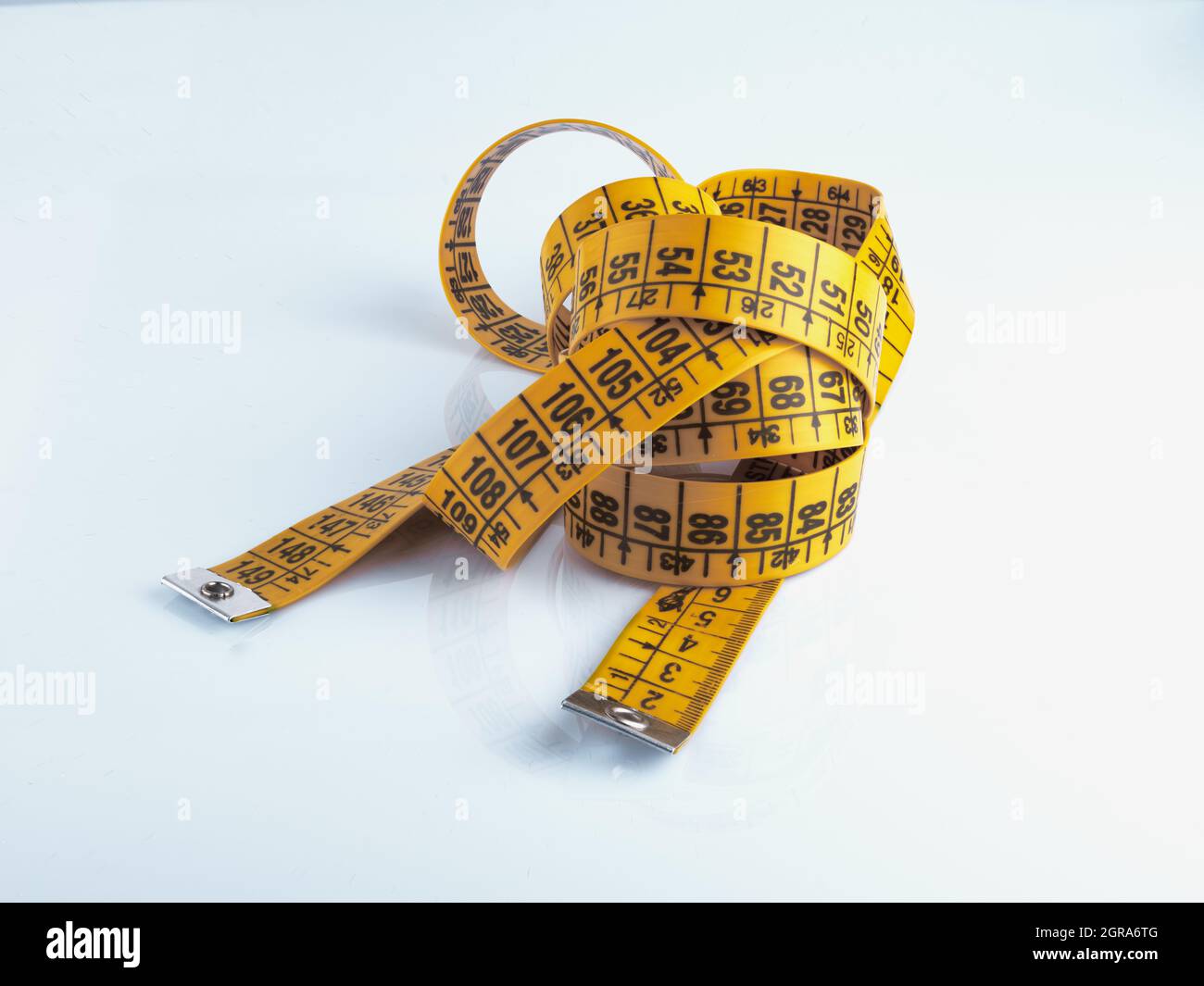 Yellow measuring tape isolated on white background Stock Photo - Alamy