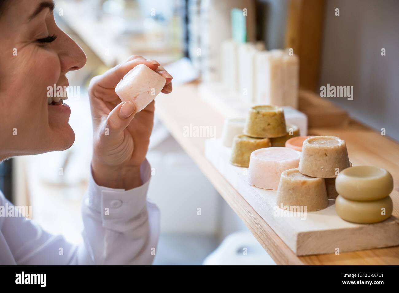 Woman sniffing organic soap while choosing at eco friendly store Stock ...
