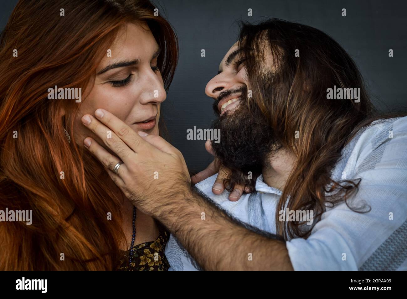 Portrait of a young couple where the young man with beard and long hair ...