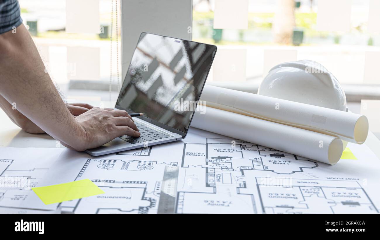Young Man With A Laptop Plotting A System Of Building Structures In ...