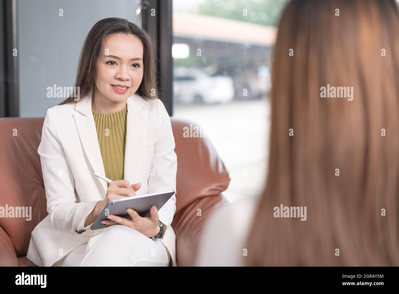 Female Southeast Asian psychologist doctor consults in a psychotherapy ...