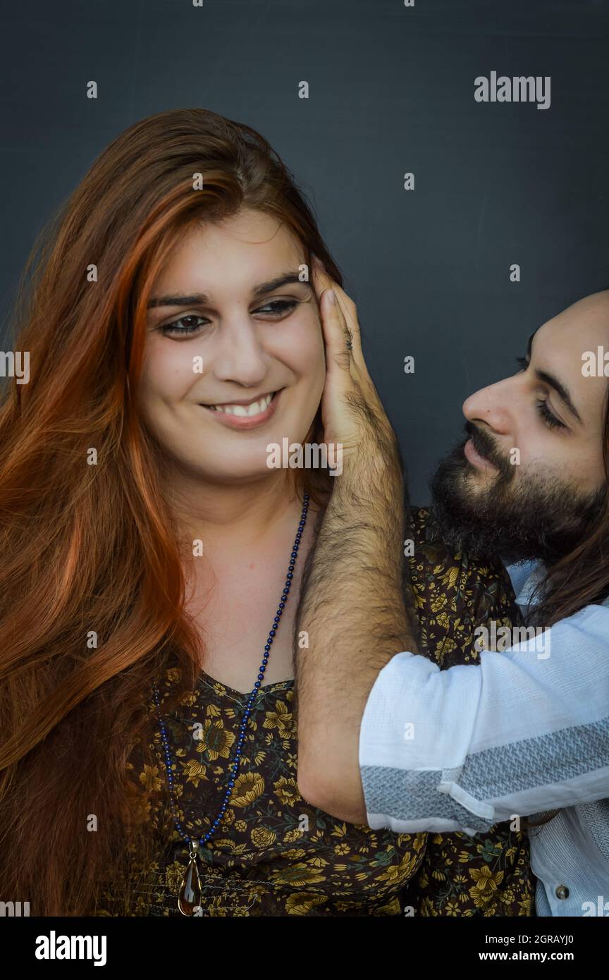 Portrait Of A Young Couple Where The Young Man With Beard And Long Hair Caresses The Face Of The