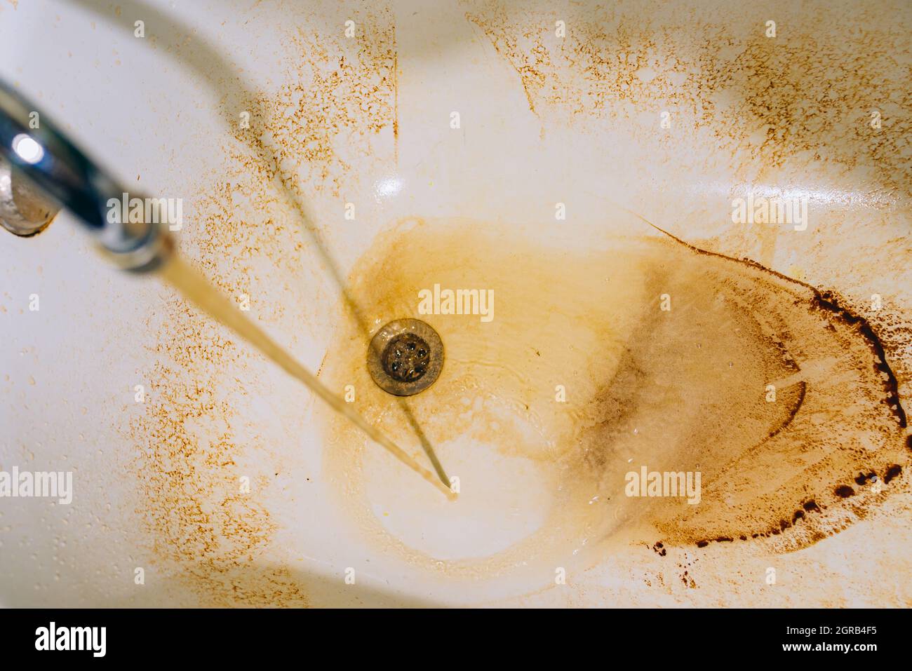 Rusty water flows from the tap into the bathtub Stock Photo - Alamy
