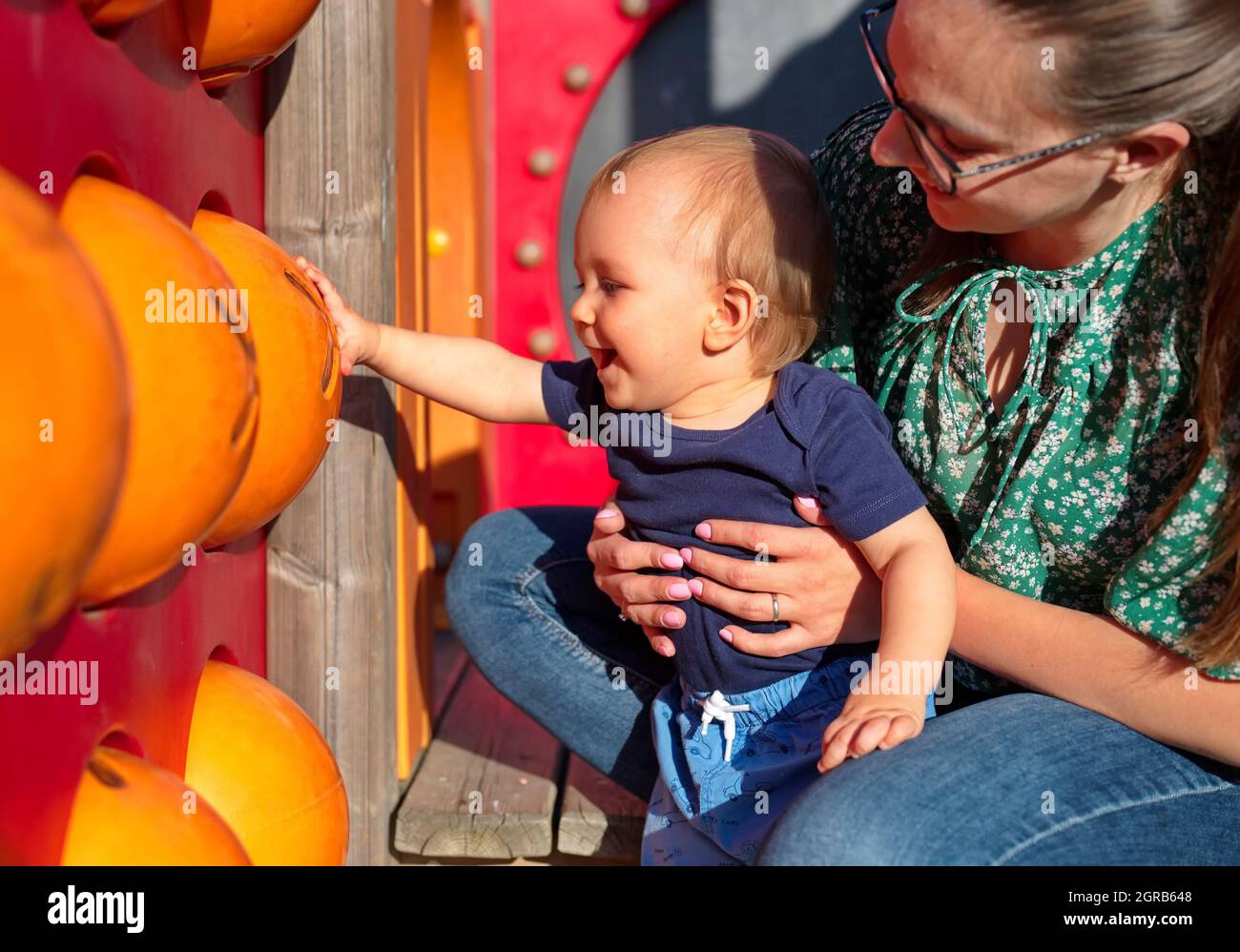 Mother and her cute little baby having fun on the playground Stock ...