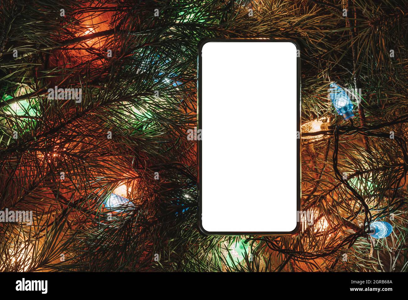 Smartphone surrounded by Christmas tree and accessories. Smartphone ...