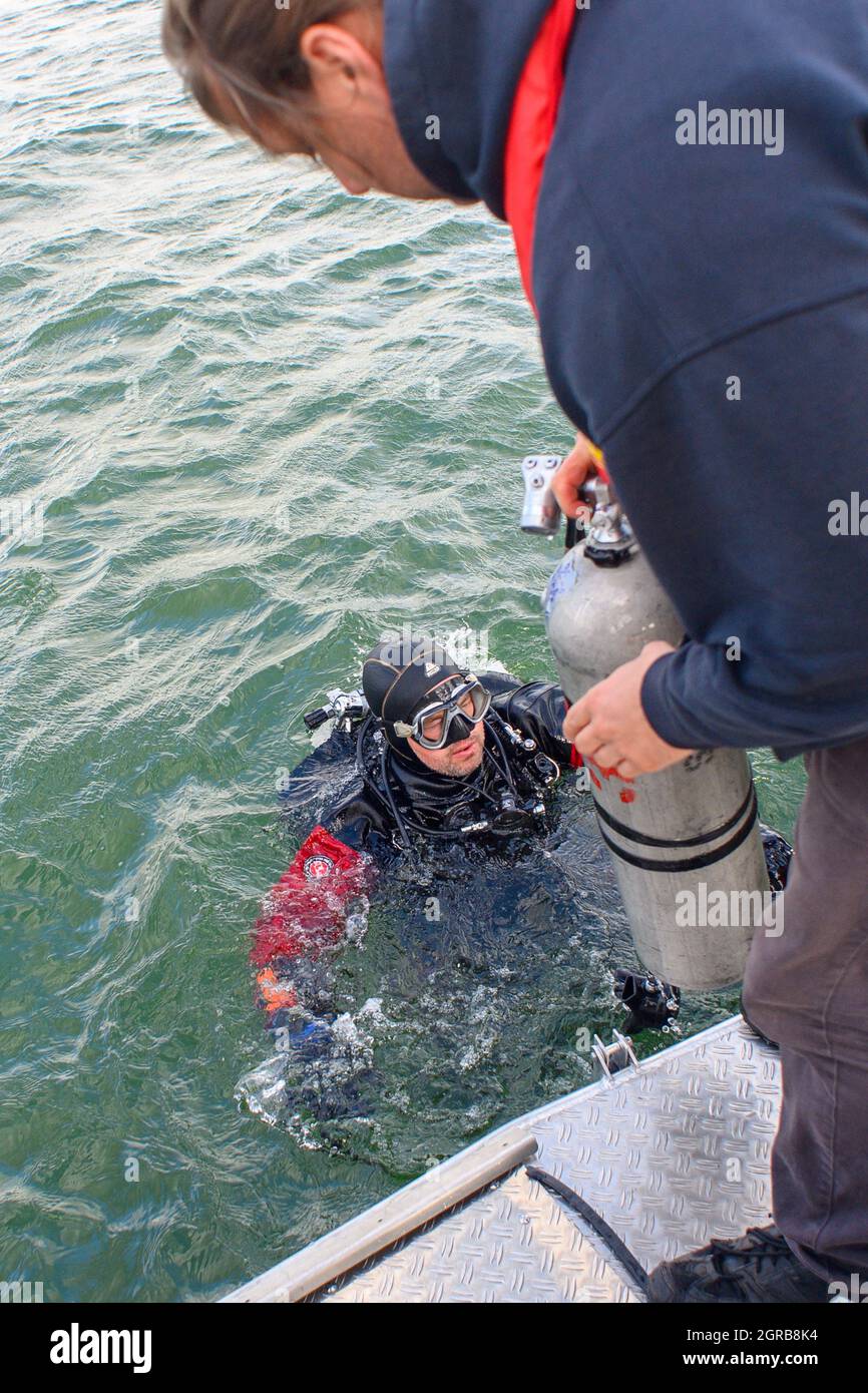 30 September 2021, Saxony-Anhalt, Arendsee: A helper takes diving ...