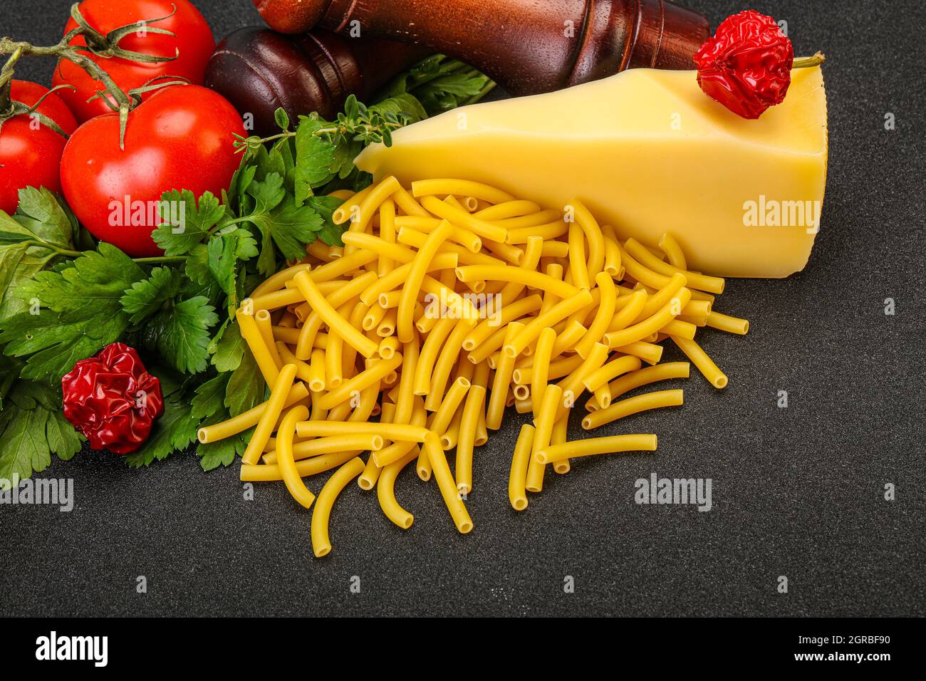 Italian pasta raw Maccheroni for cooking served vegetables Stock Photo ...