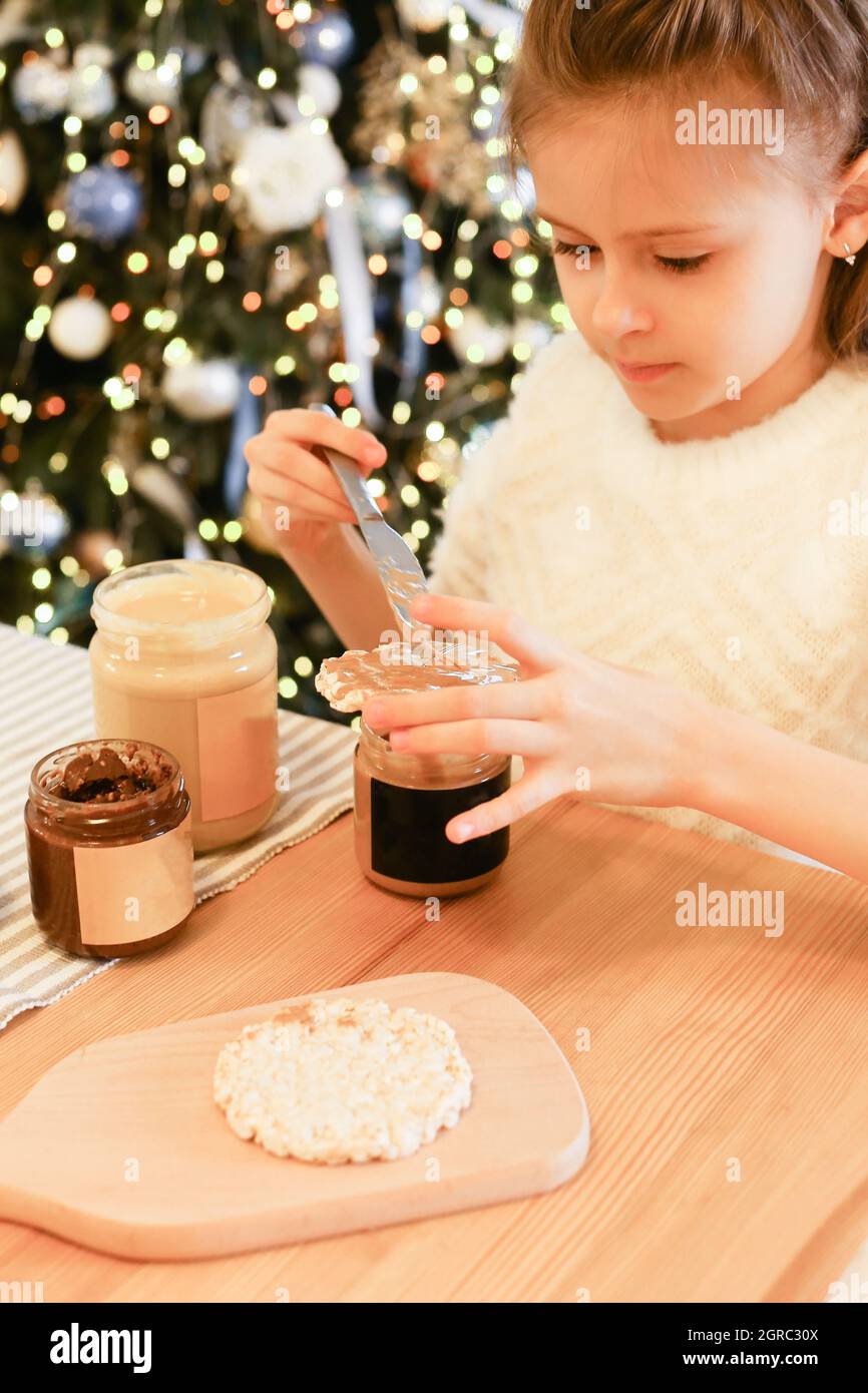 A young girl eat peanut butter on Holiday Christmas background Stock ...