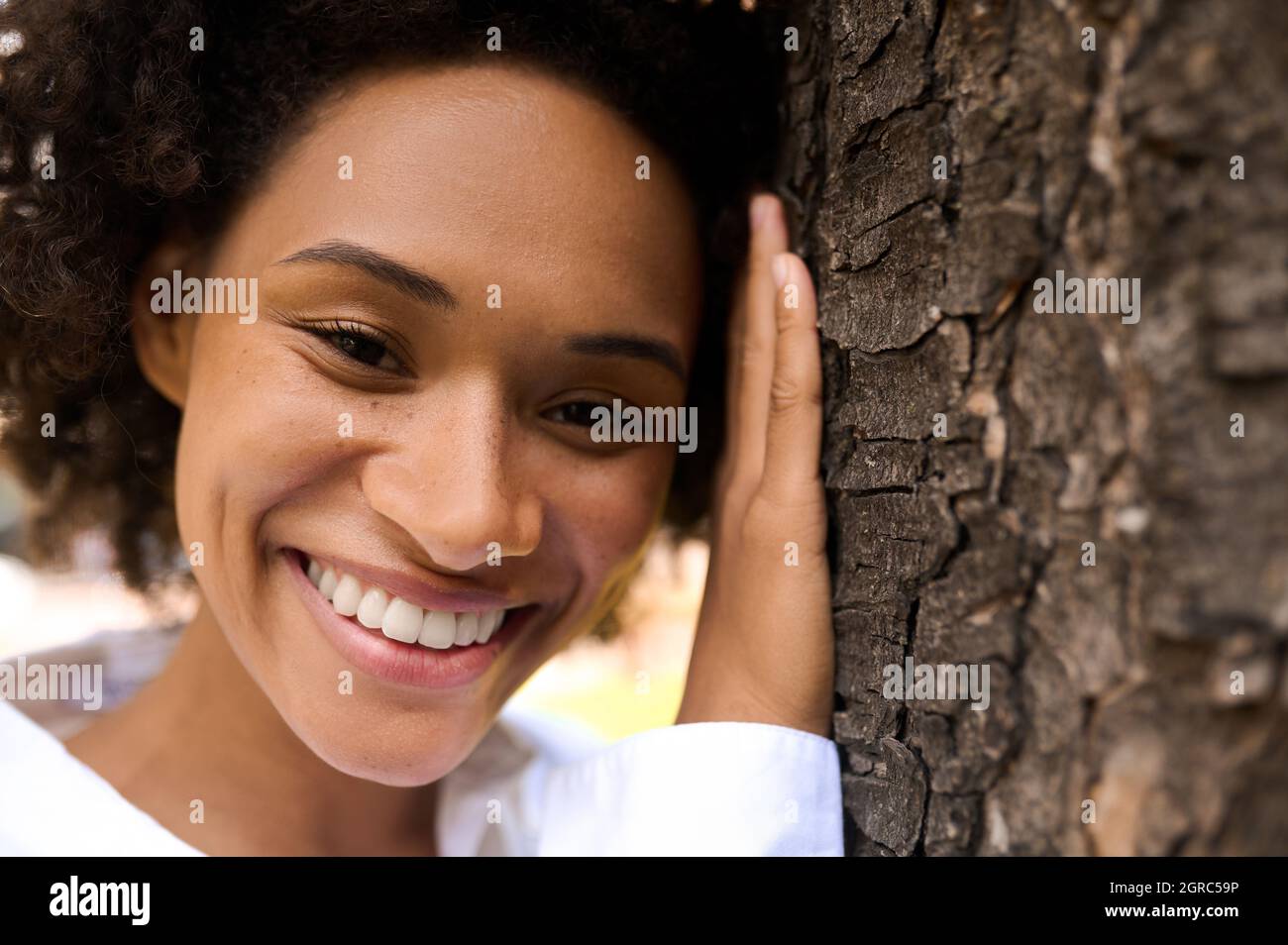A pretty mulatta looking relaxed and happy spending time in the park ...