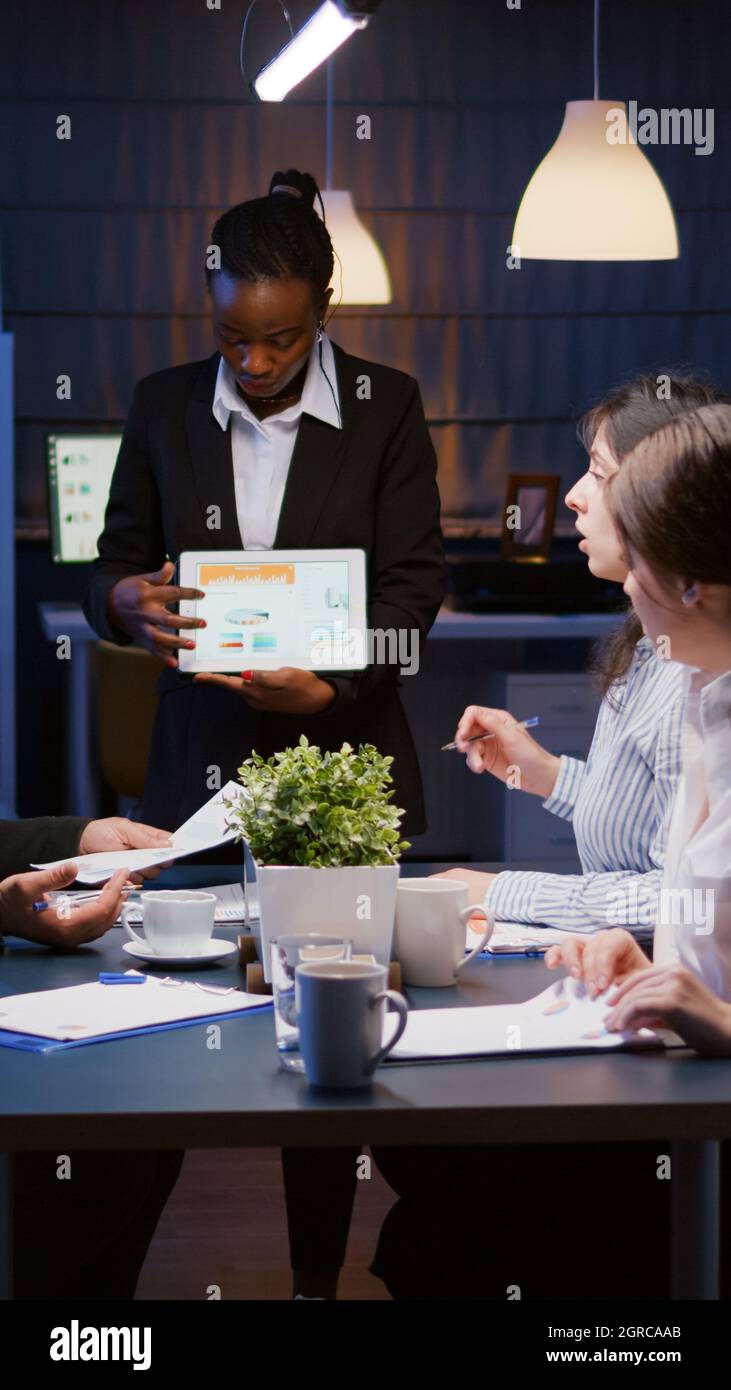 Exhausted workaholic african american showing financial graphs using ...